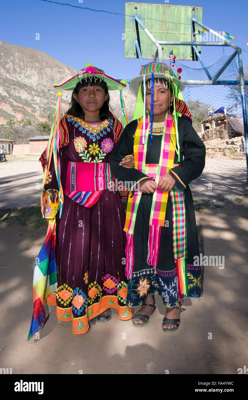 Colourful dancers in traditional costumes and masks, spectators, in a ...