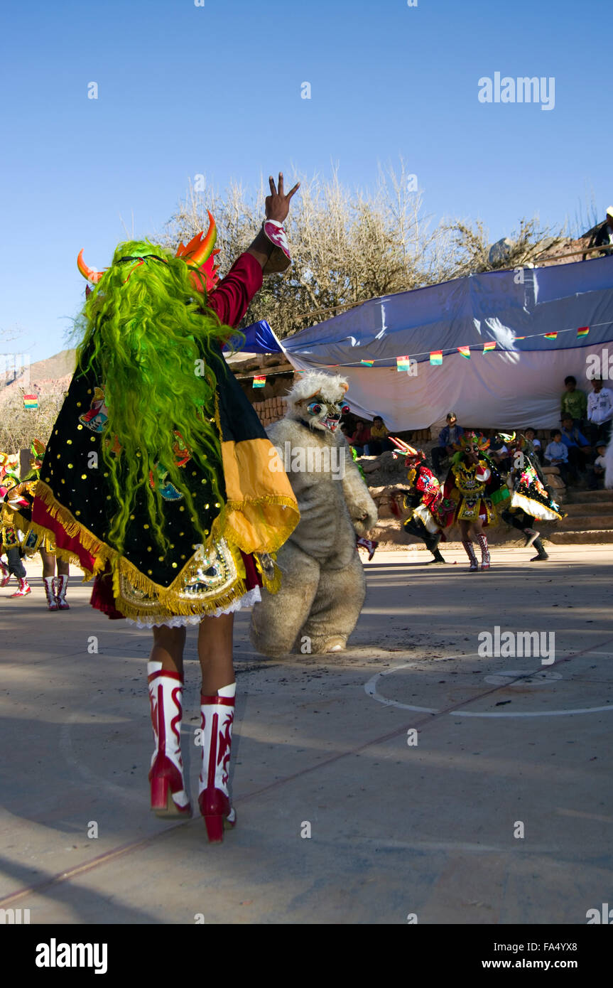 Dancers in traditional costumes and masks, spectators, musicians in a ...