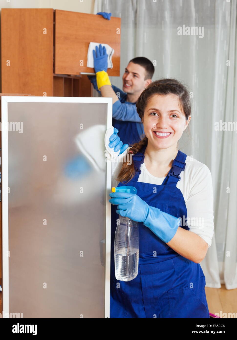 Two handsome cleaners cleaning furniture in room Stock Photo - Alamy