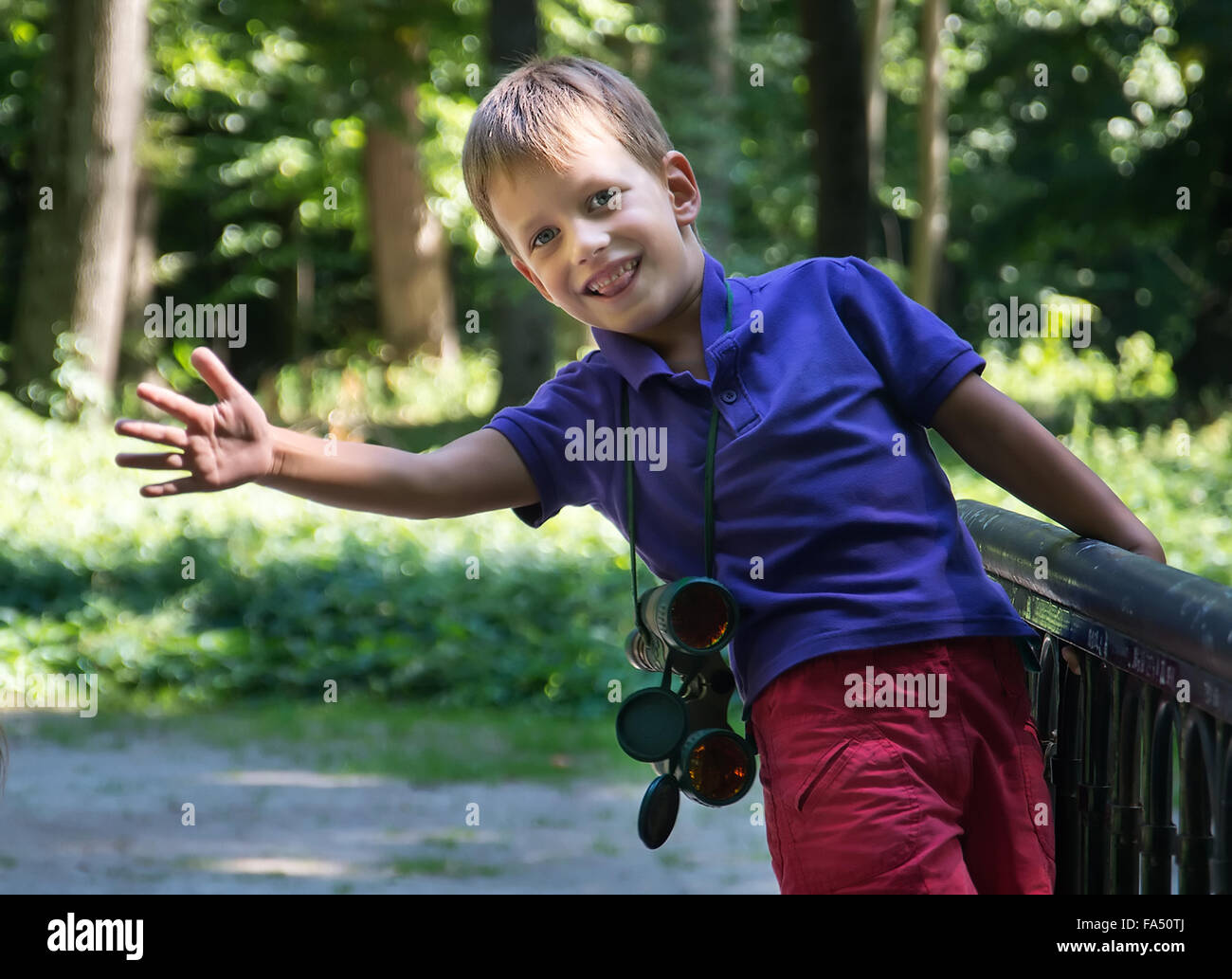 Boy on bridge shaking his hand with binoculars Stock Photo - Alamy
