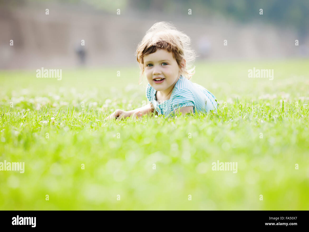 three year old child playing at grass meadow Stock Photo - Alamy