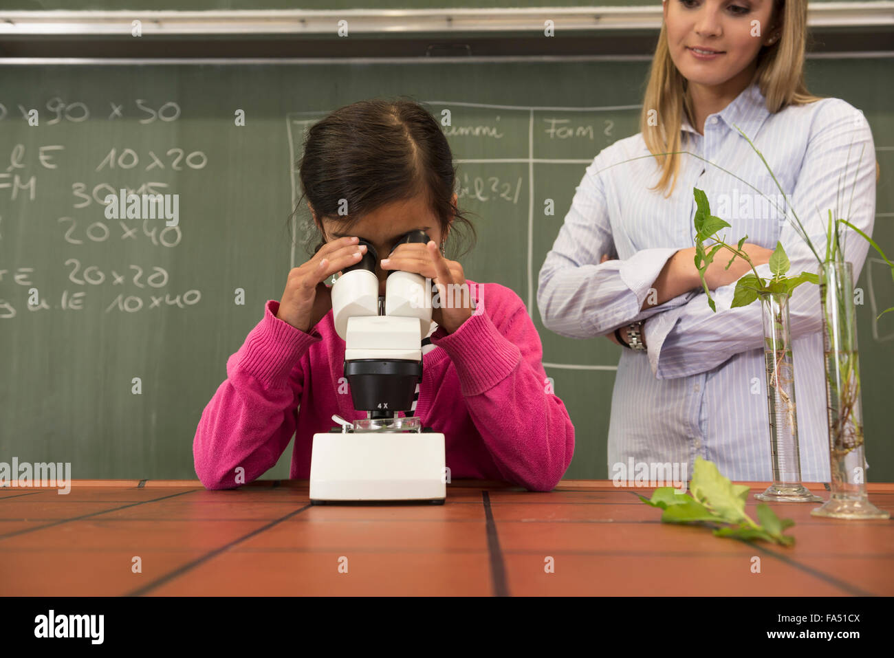 school girl with teacher looking through a microscope, Fürstenfeldbruck ...