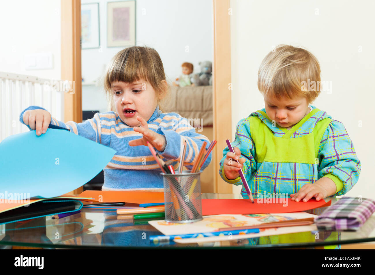 serious children playing with paper and pencils in home interior Stock ...