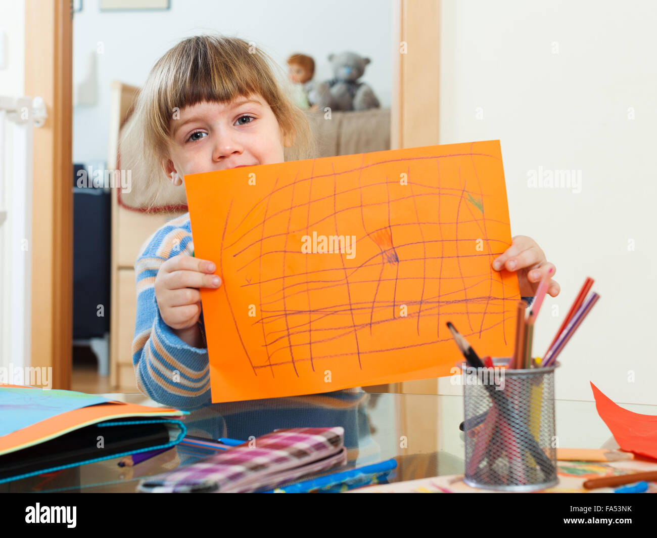 serious child showing drawed paper in home interior Stock Photo - Alamy