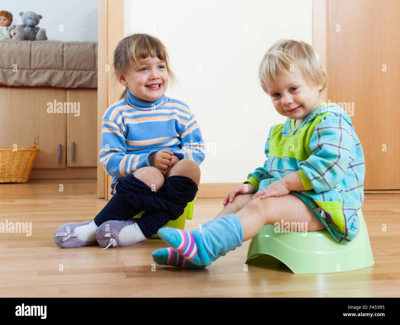 Baby girls sitting on potties in home interior Stock Photo - Alamy