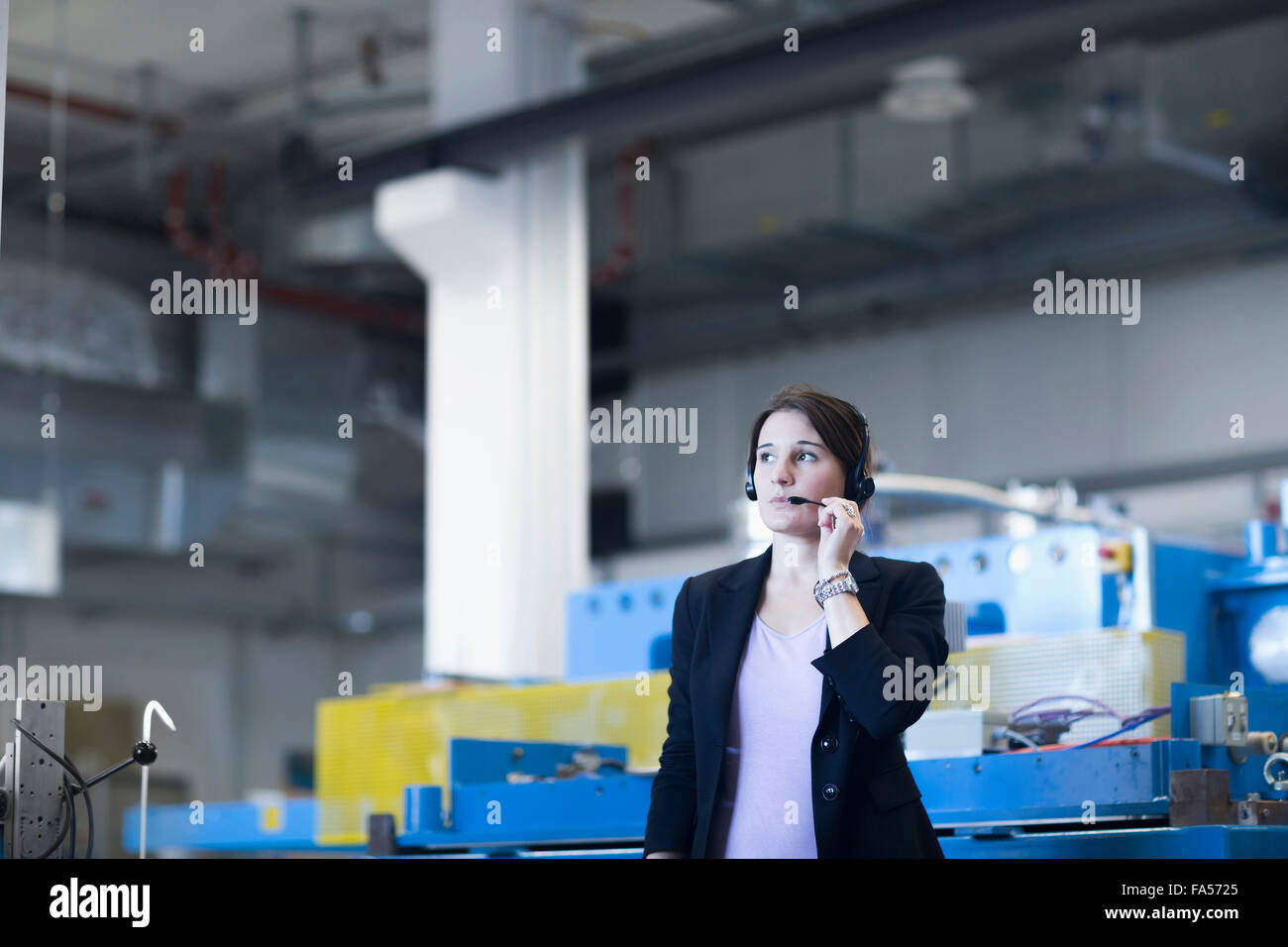 Female engineer wearing headset in an industrial plant, Freiburg Im ...