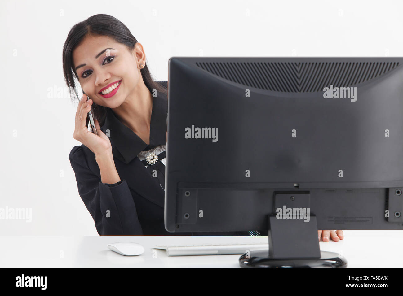 woman sitting in front of the monitor talking on the phone Stock Photo ...