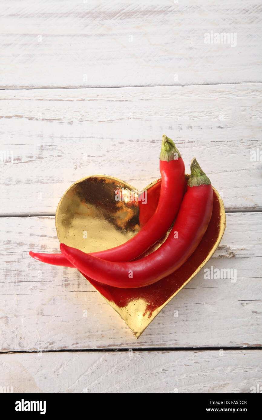 red chili on the golden heart shape container Stock Photo - Alamy