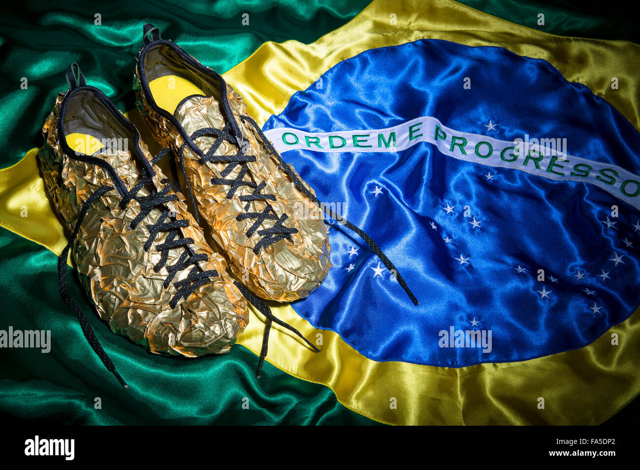 Golden running shoes resting on shiny Brazilian flag still life Stock ...
