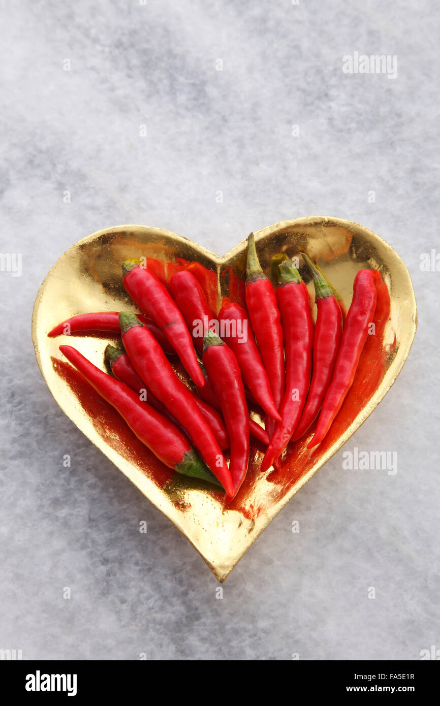 red chili on the golden heart shape container Stock Photo - Alamy