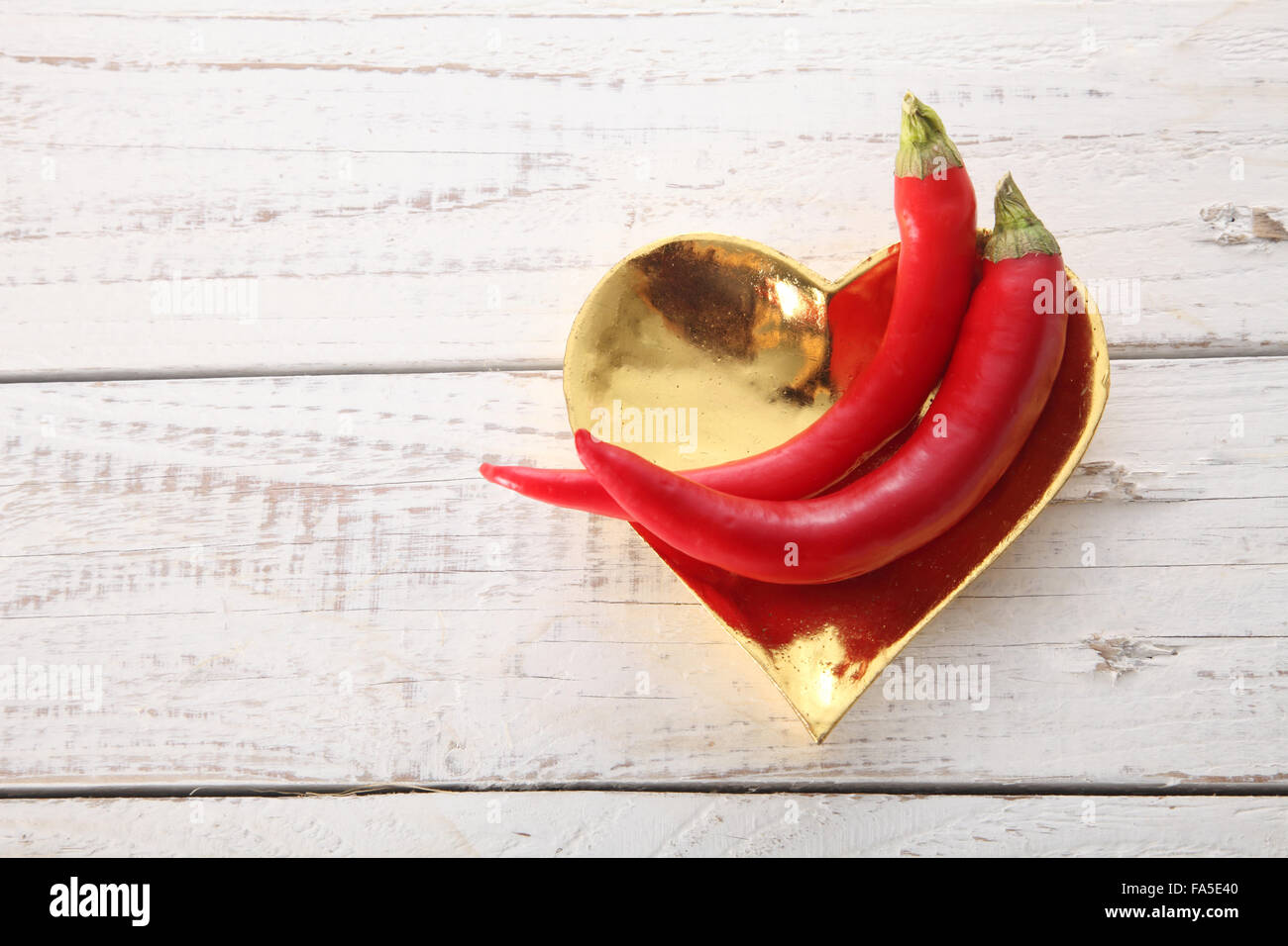 red chili on the golden heart shape container Stock Photo - Alamy