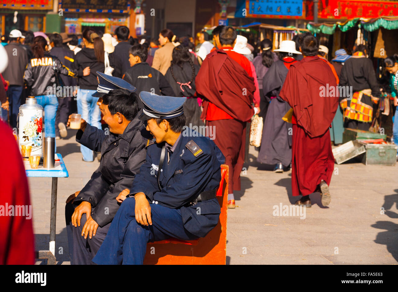 Chinese police sitting outside in uniform together guarding the Jokhang ...