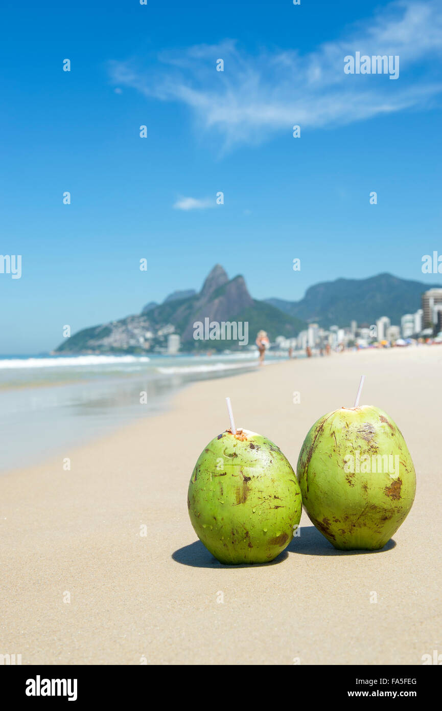 Two coco verde green coconuts on Ipanema Beach against a backdrop of ...