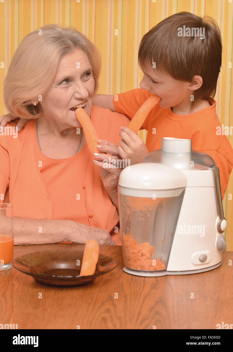 Woman and grandson eating carrots Stock Photo - Alamy