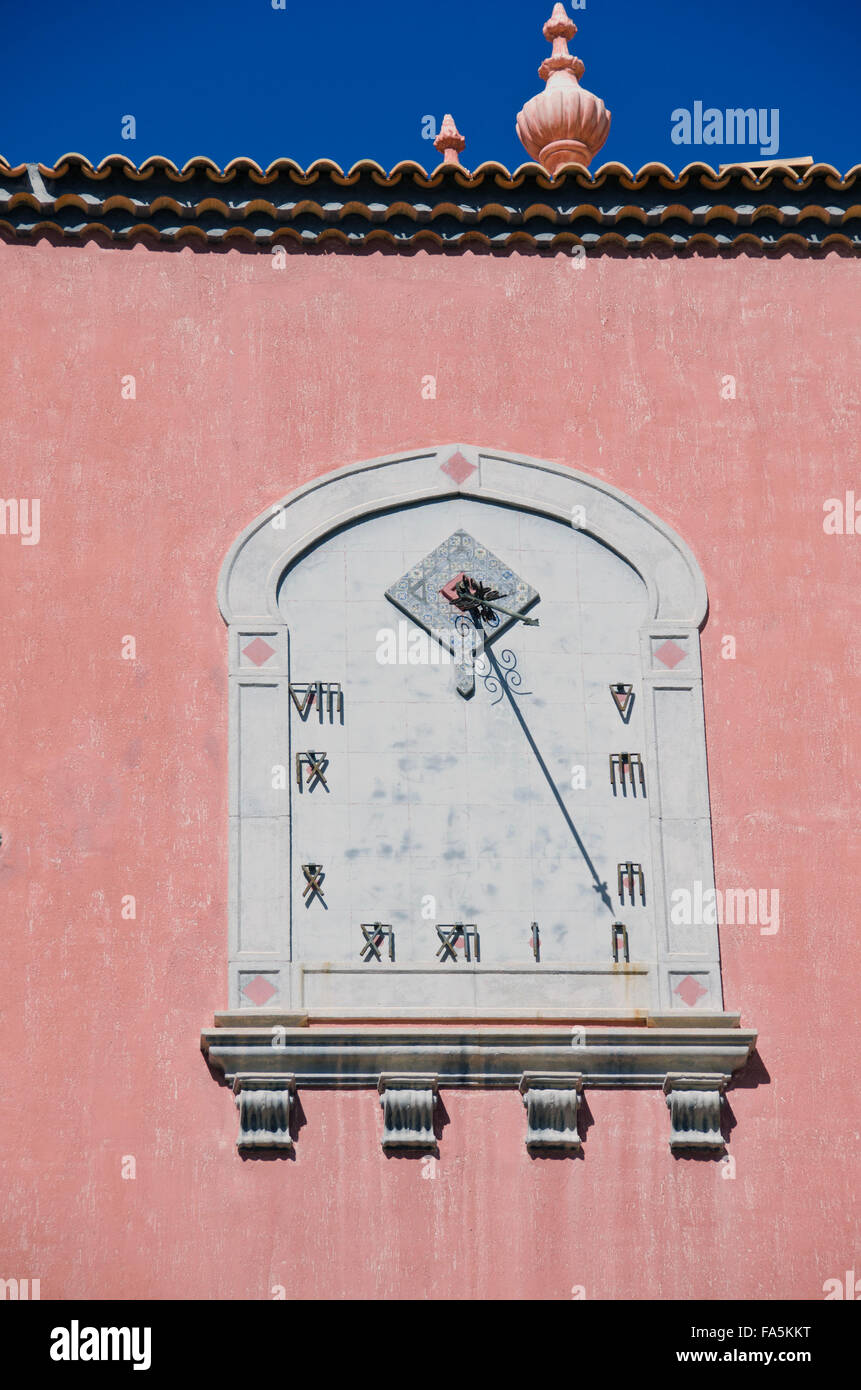 Sunlit oman numeral sundial on pink house wall Stock Photo - Alamy
