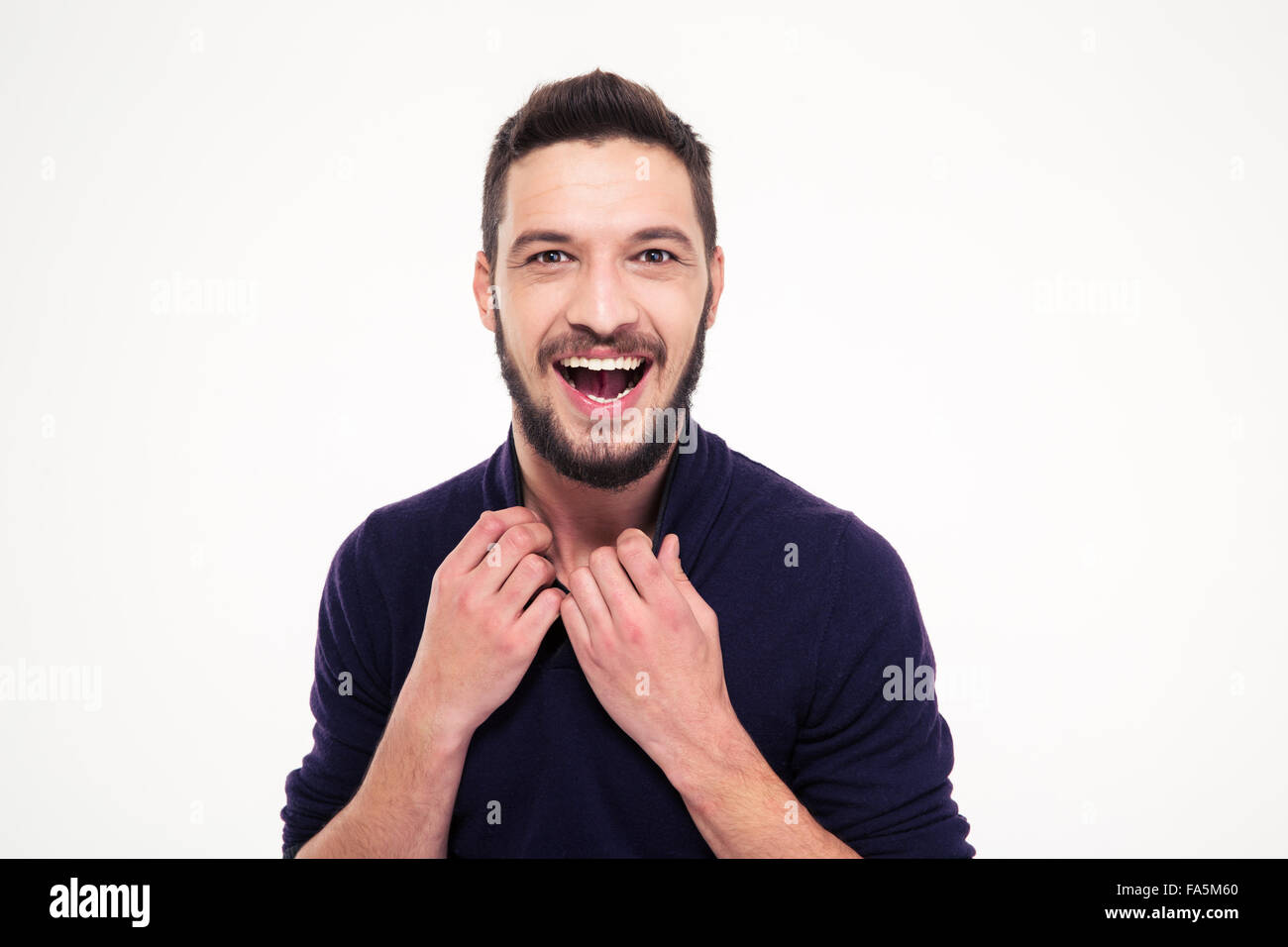 Excited attractive happy young bearded man laughing and looking camera ...