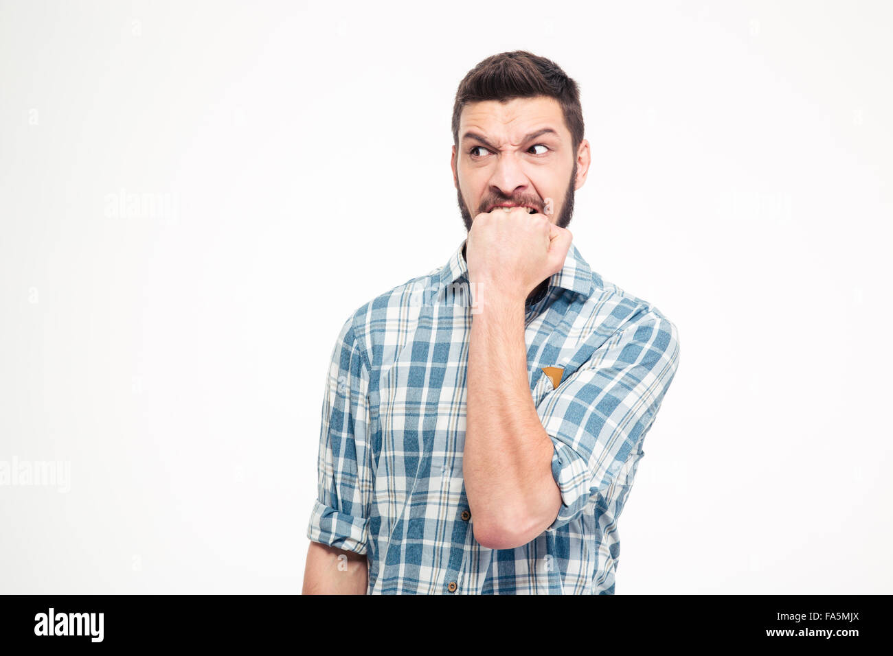 Angry irritated aggressive young bearded man in plaid shirt biting his ...