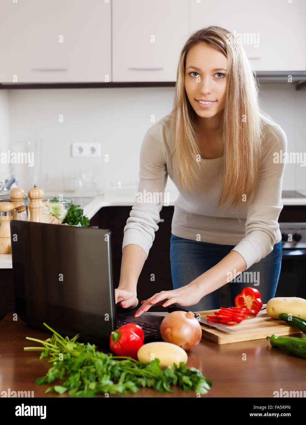 Casual woman using notebook while cooking lunch at home kitchen Stock ...