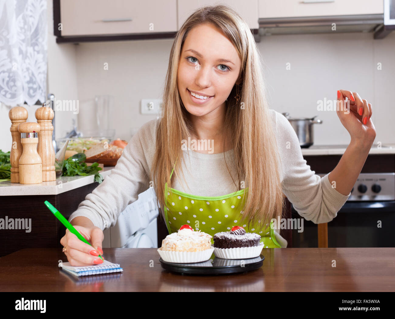 Woman weighing cakes on kitchen scales at kitchen Stock Photo - Alamy