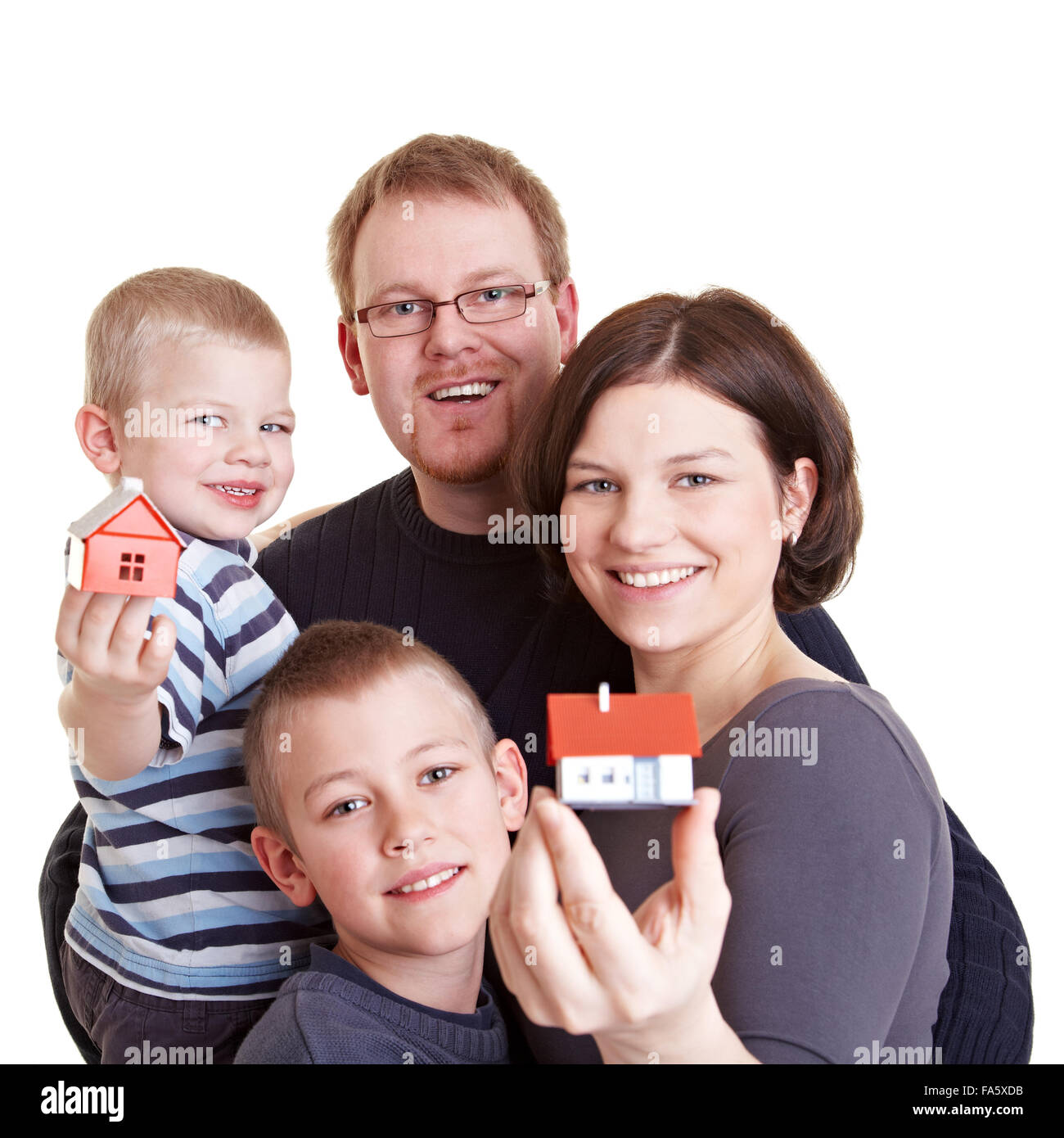 Happy family with two children holding small houses Stock Photo - Alamy