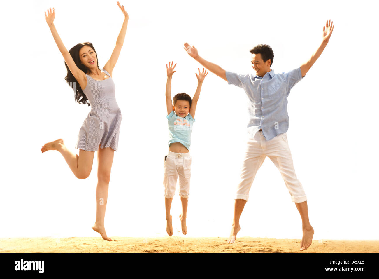 Family jumping on beach Stock Photo - Alamy