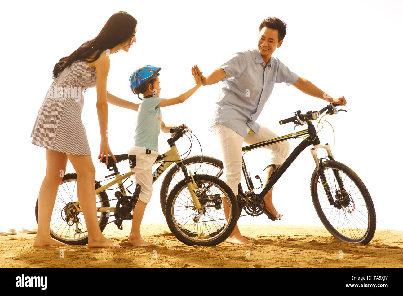 Family on beach riding bicycle hi-res stock photography and images - Alamy