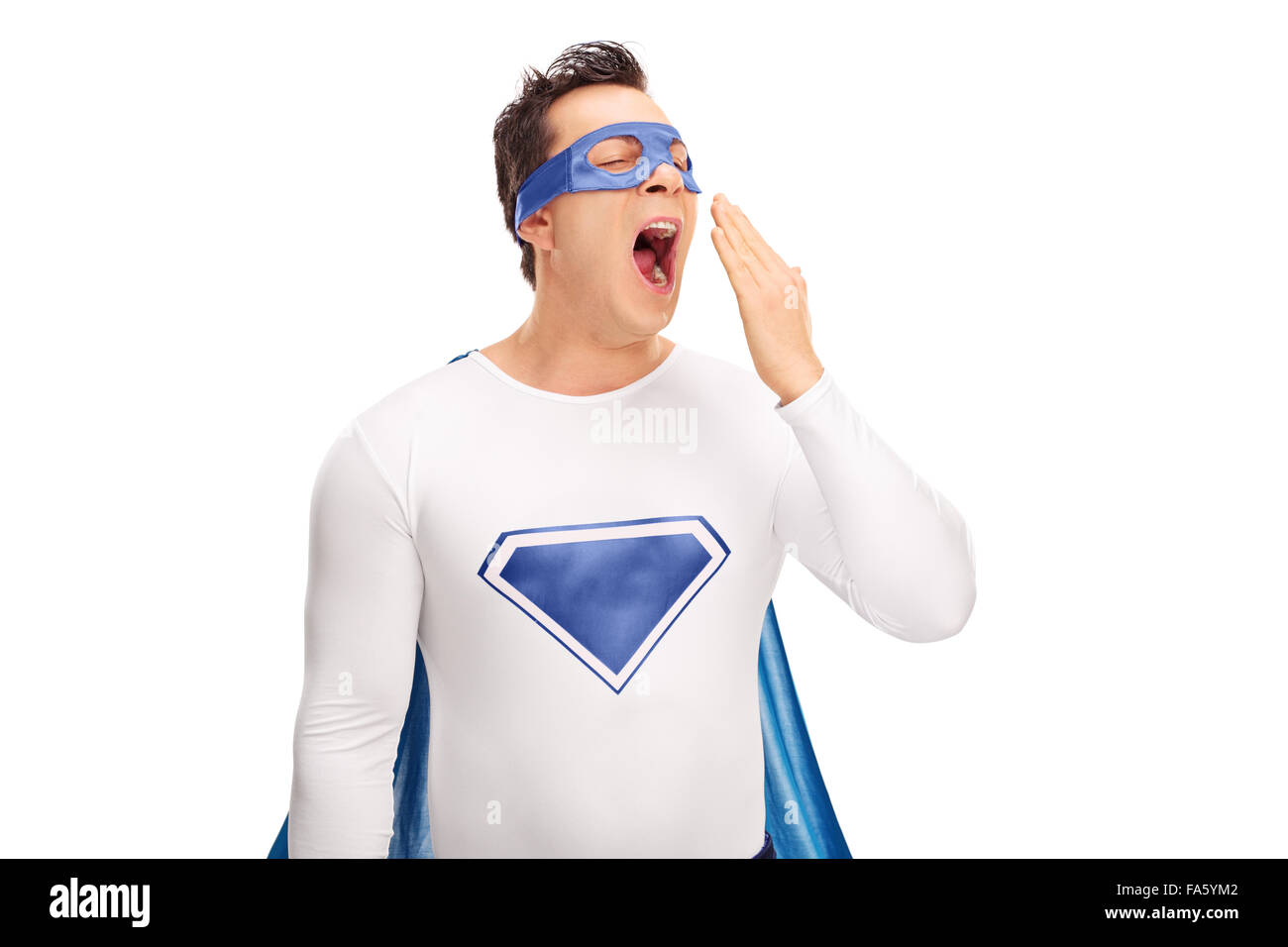 Studio shot of a male superhero yawning and covering his mouth with his ...
