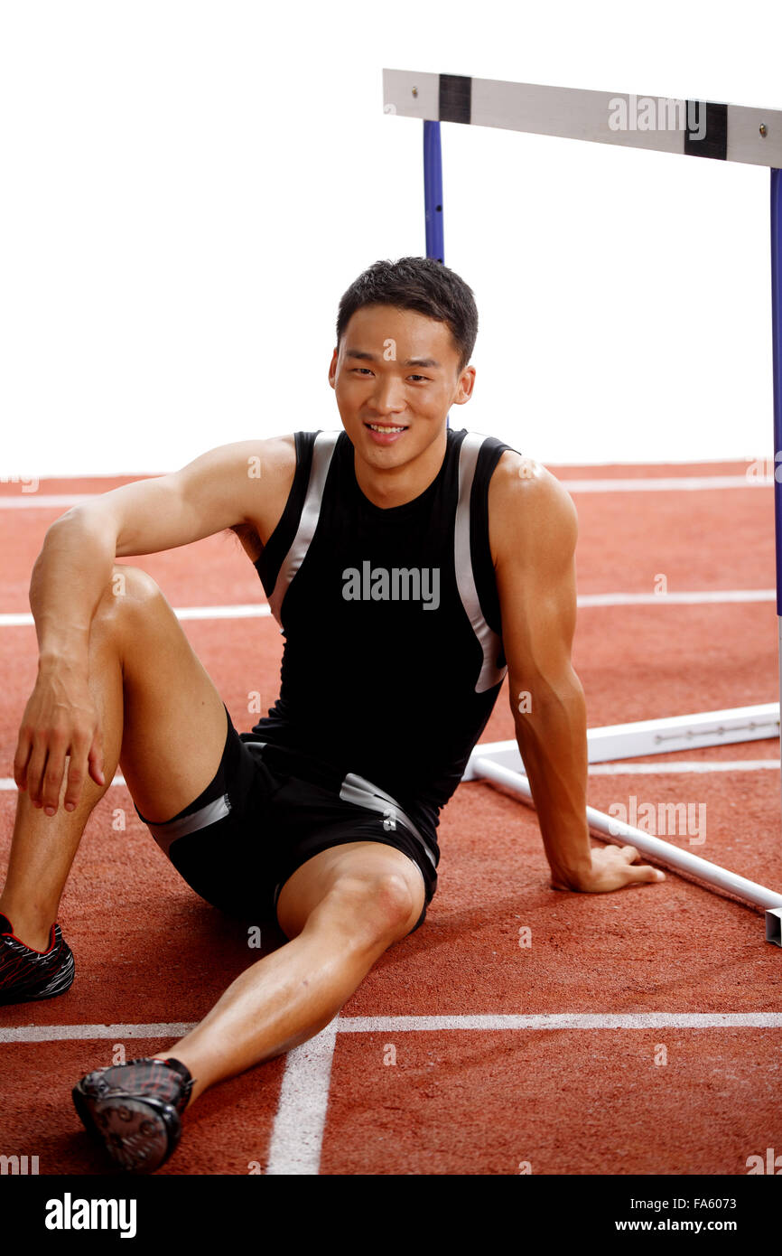 The track and field athlete is sitting on the track Stock Photo - Alamy