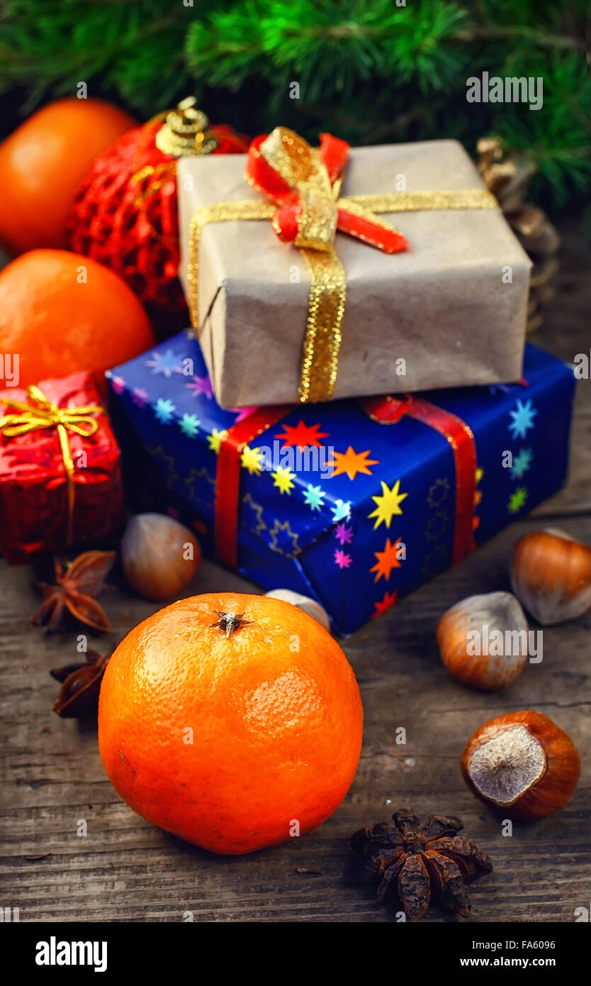 Two small boxes with gifts on the background of tangerine,spruce branch ...