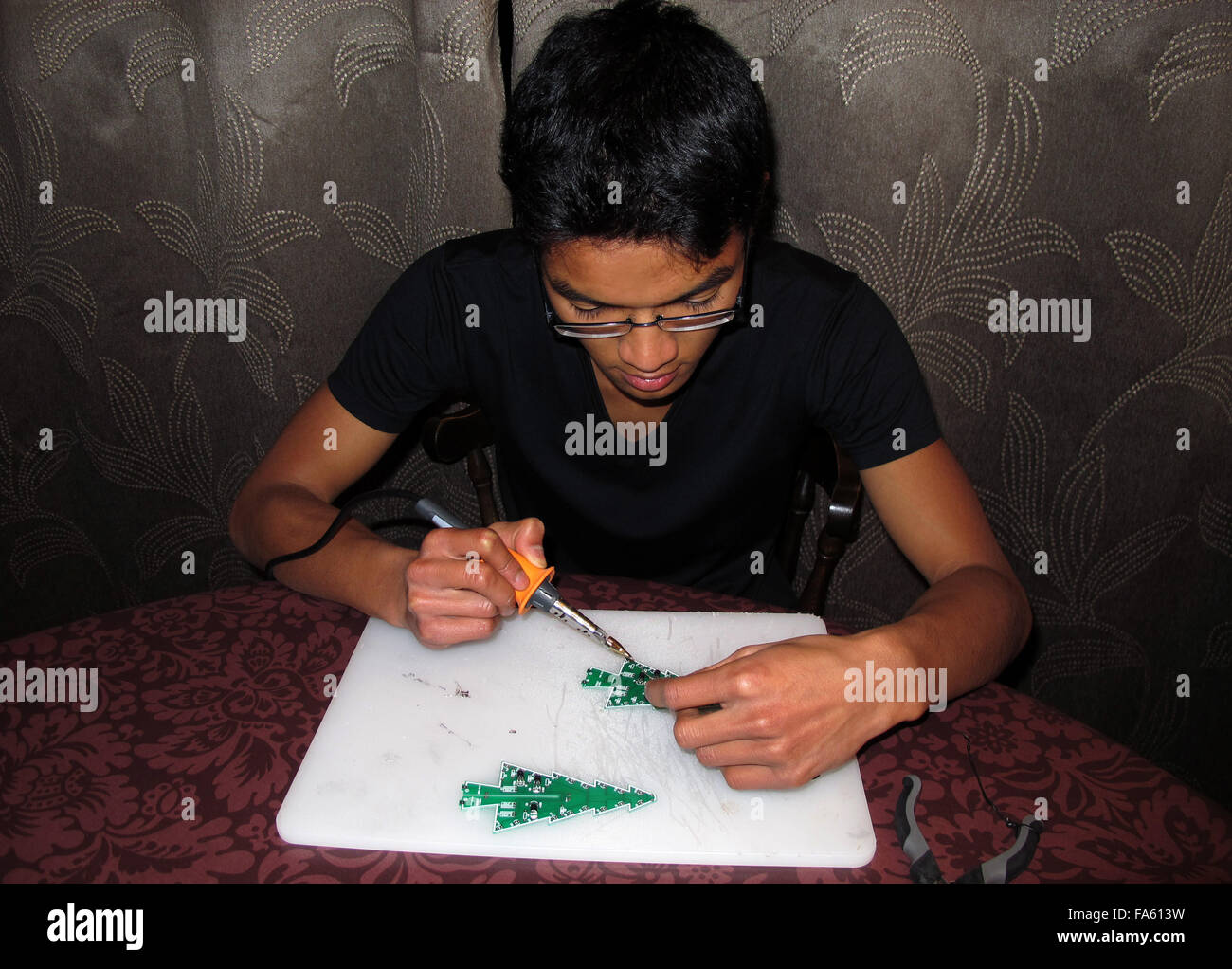 Boy soldering a transistor on a Christmas tree Stock Photo - Alamy