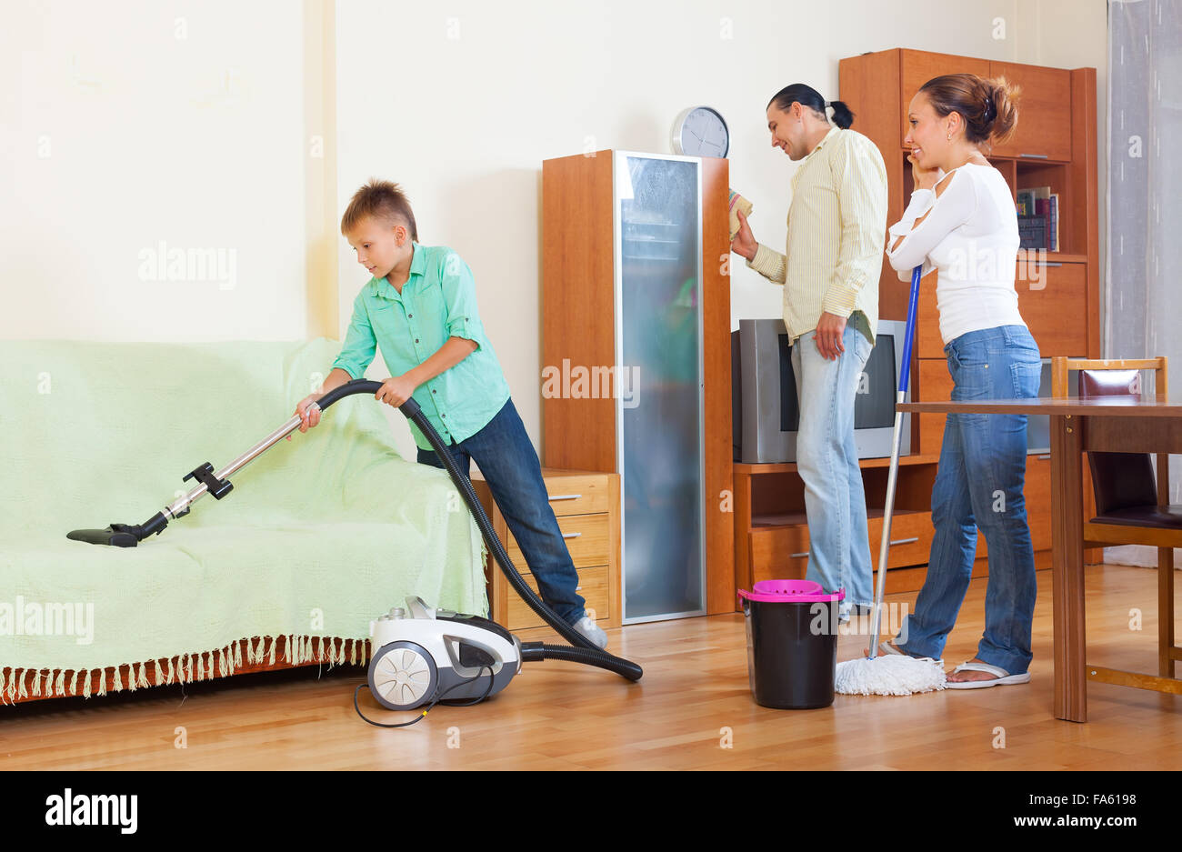 middle-aged parents with teenage son doing house cleaning in home Stock ...