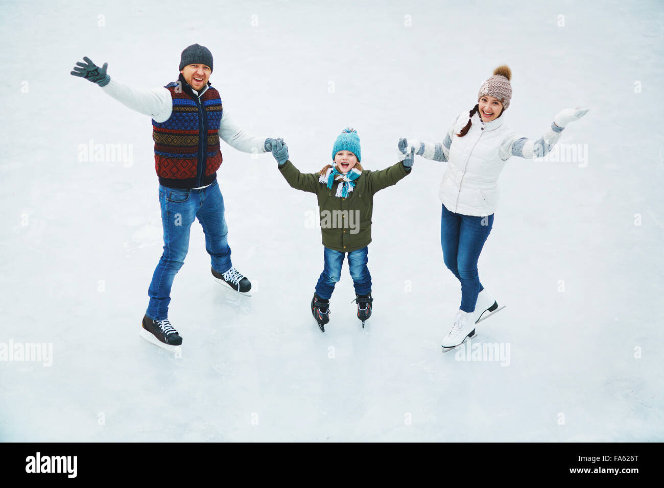 Happy family of skaters looking at camera on skating-rink Stock Photo ...