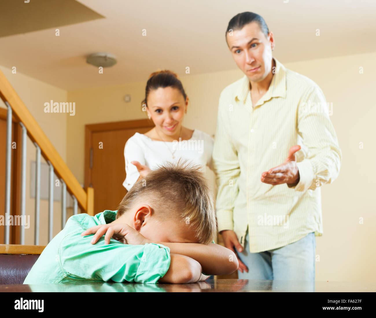 Parents scolding her teenage child in home interior. Focus on boy Stock ...