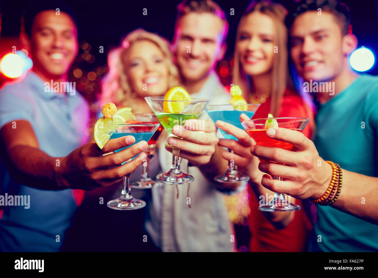 Group of friends holding cocktails and cheering up Stock Photo - Alamy