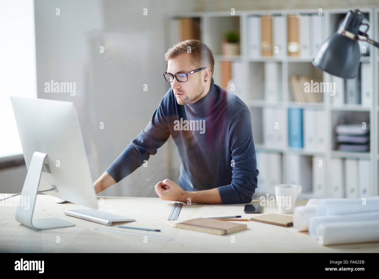 Young businessman working in front of computer in office Stock Photo ...
