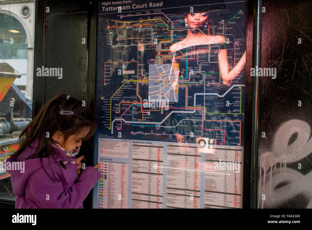 A young girl with a bus route map of London with reflections of the ...