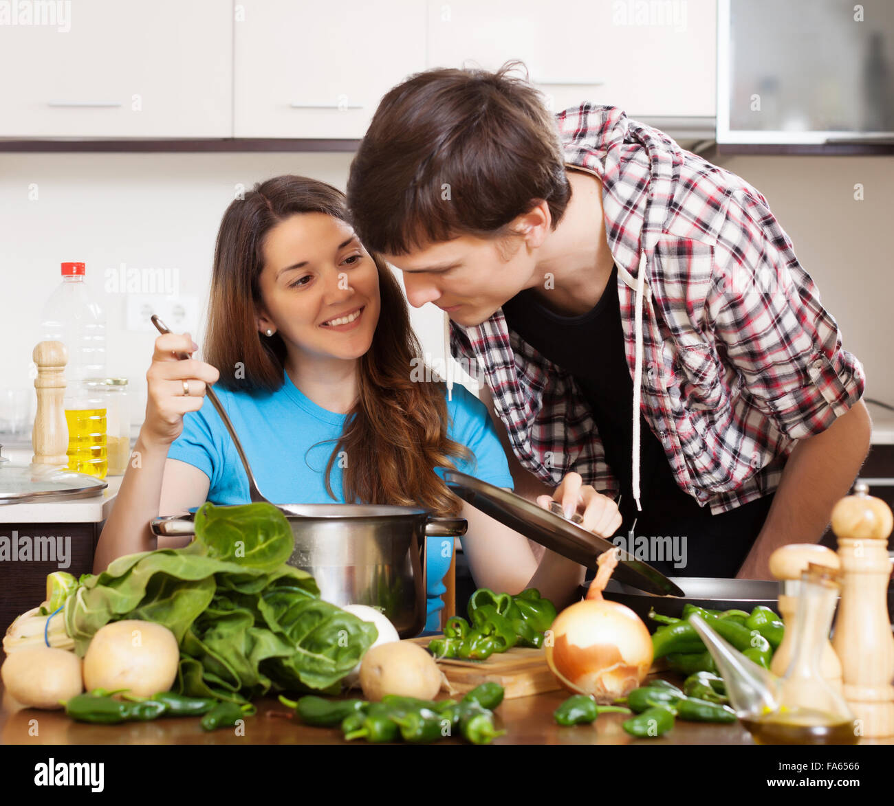 man and young woman cooking together in kitchen Stock Photo - Alamy