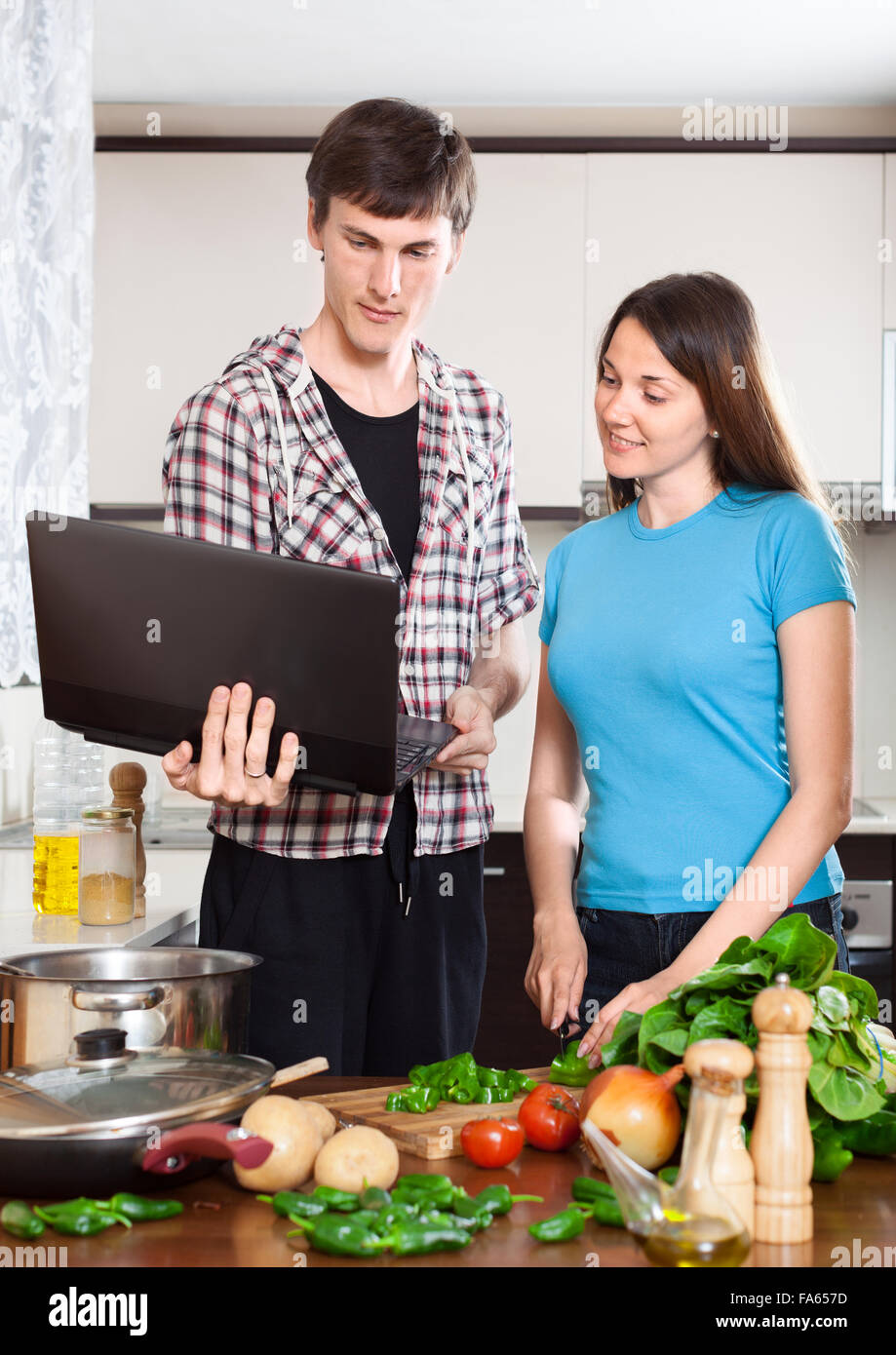 Man shows the new recipe to girl at kitchen table Stock Photo - Alamy
