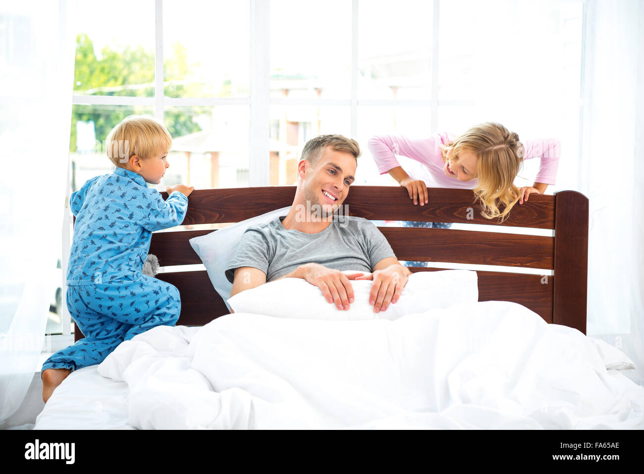 Children waking up their father Stock Photo - Alamy
