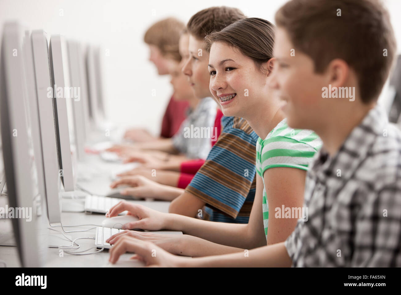A group of young people, boys and girls, students in a computer class ...