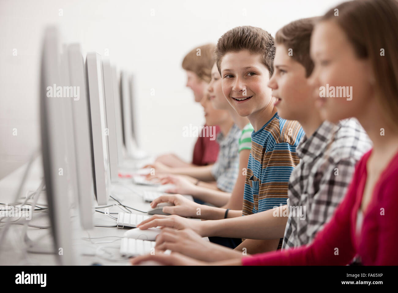 A group of young people, boys and girls, students in a computer class ...
