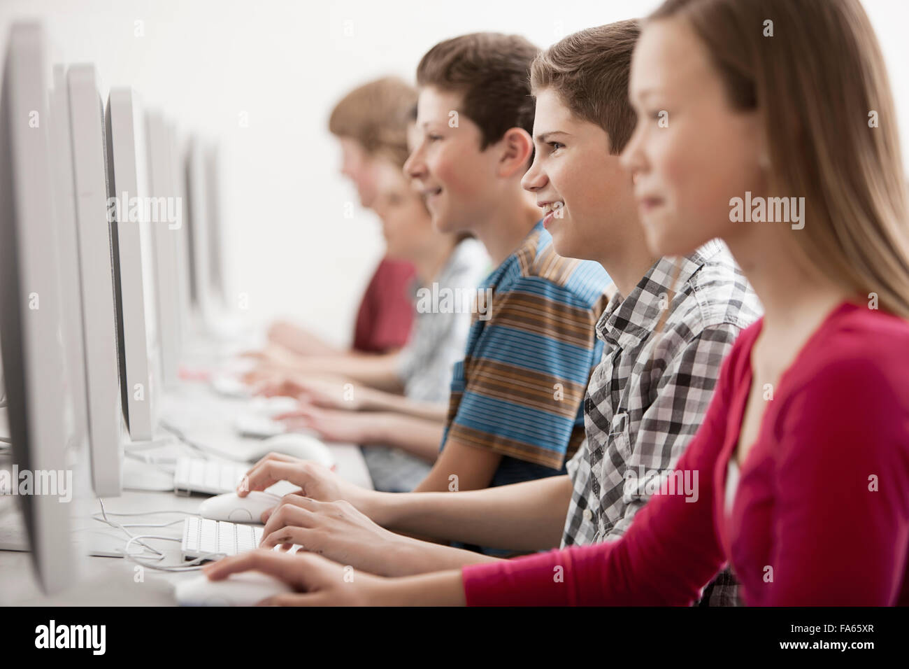 A group of young people, boys and girls, students in a computer class ...