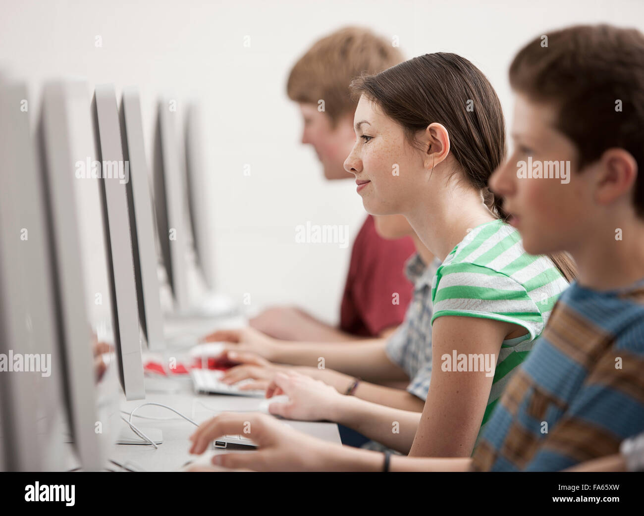 A group of young people, boys and girls, students in a computer class ...
