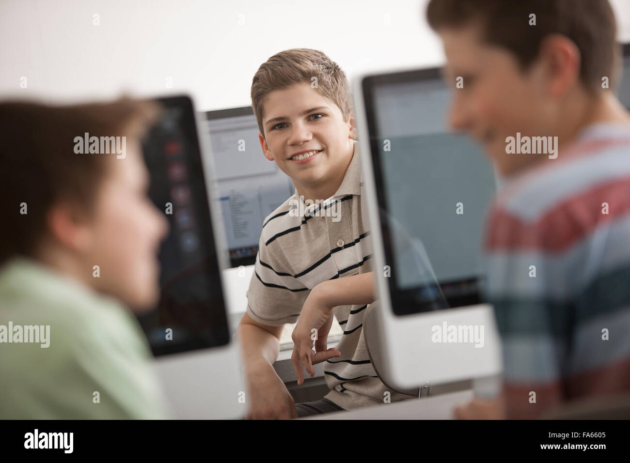 A school room computer lab with rows of computer monitors and seating ...