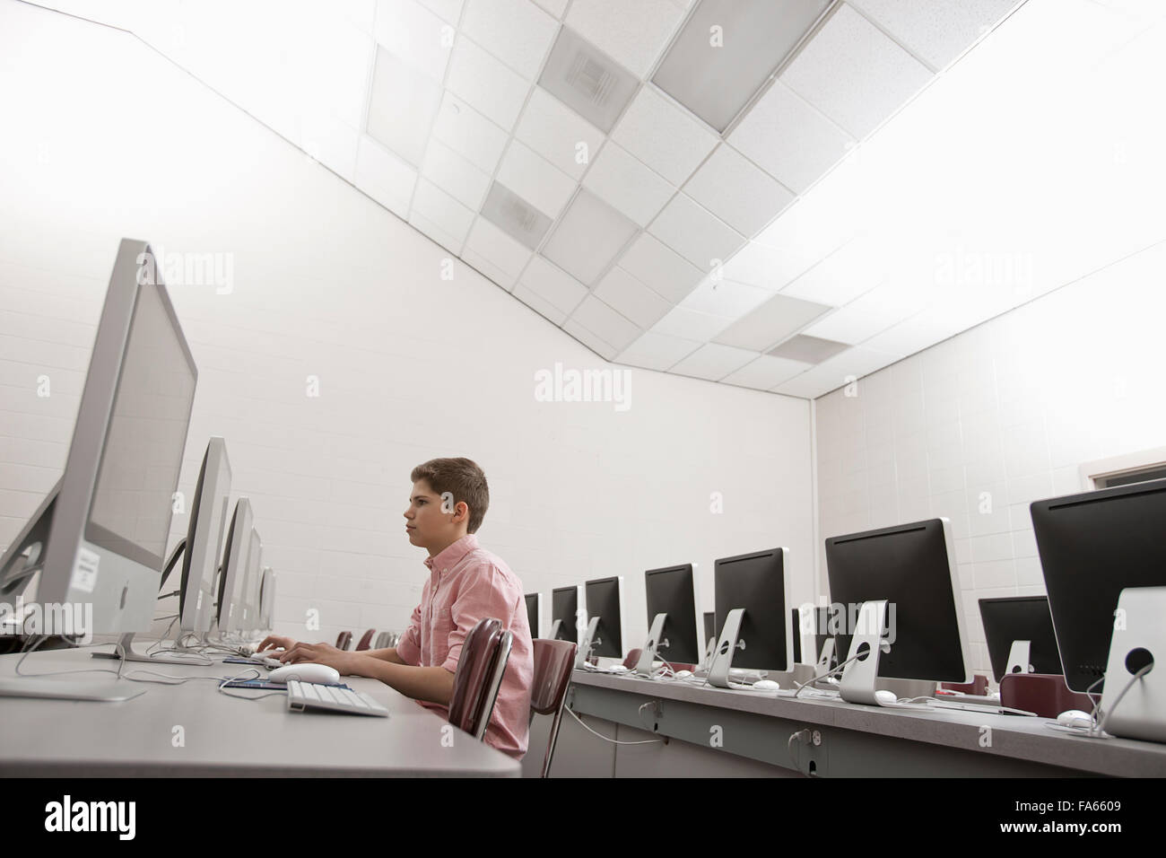 A school room, a computer lab with rows of screens and seating. A young ...