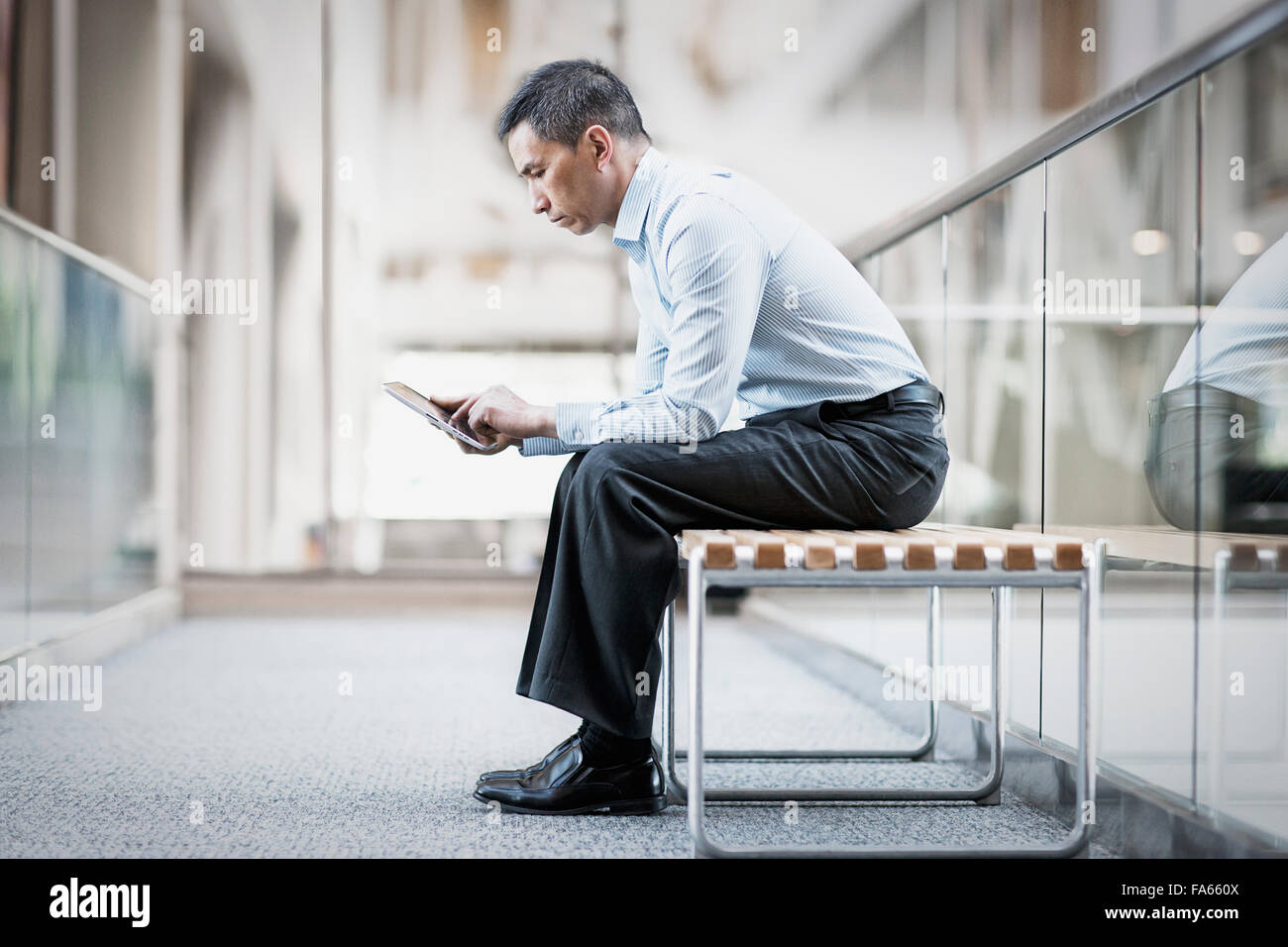A man sitting using a digital tablet Stock Photo - Alamy