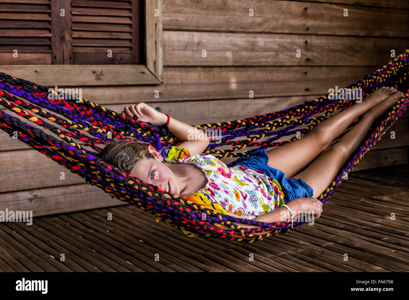 Girl lying in hammock on wooden terrace Stock Photo - Alamy