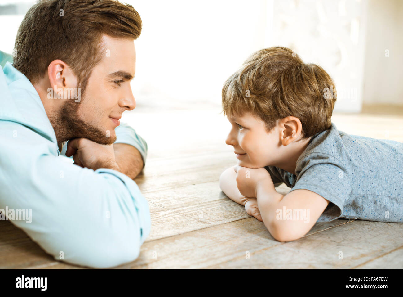 Little boy and his father on wooden floor Stock Photo - Alamy