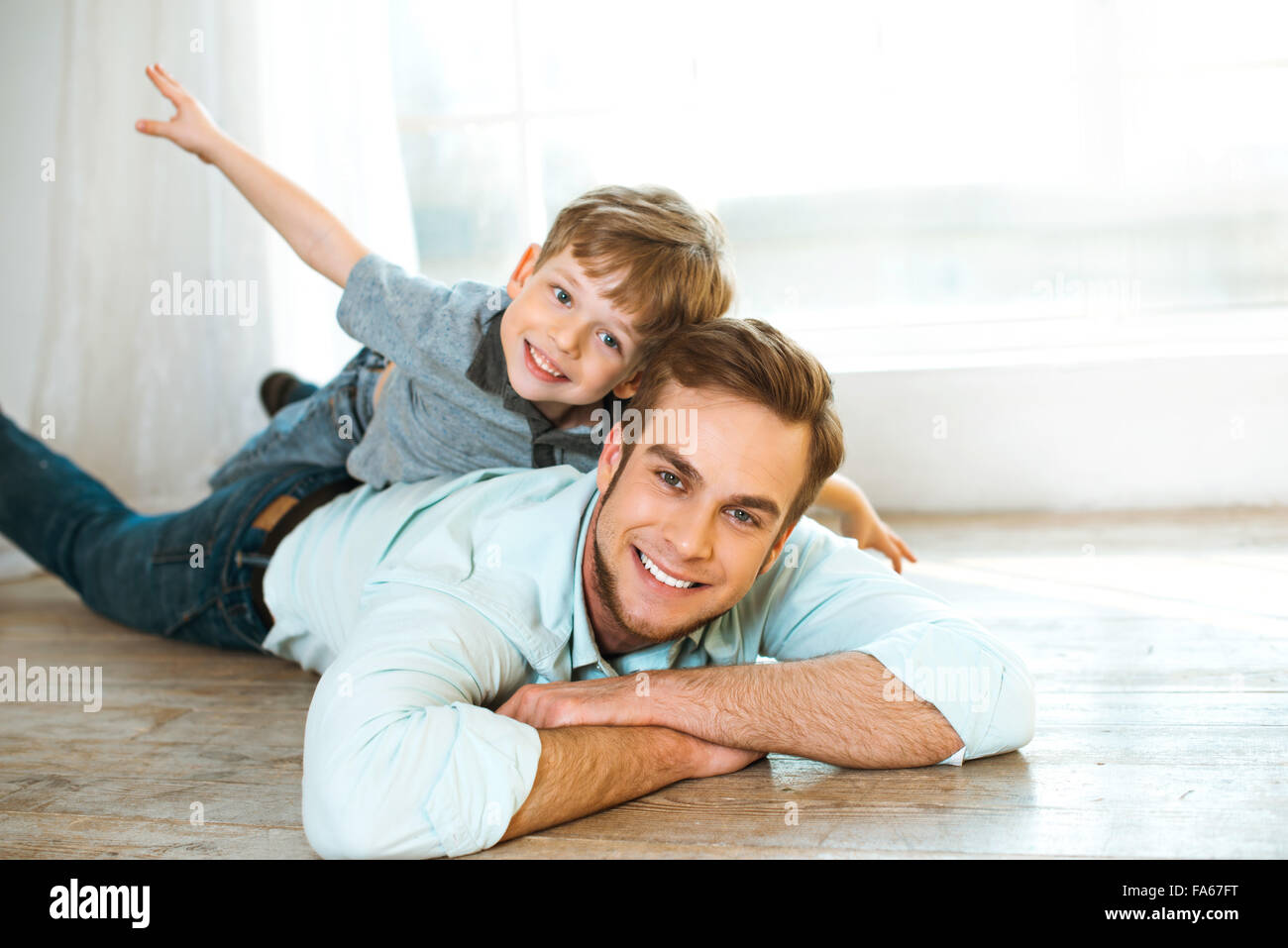 Little boy and his father on wooden floor Stock Photo - Alamy
