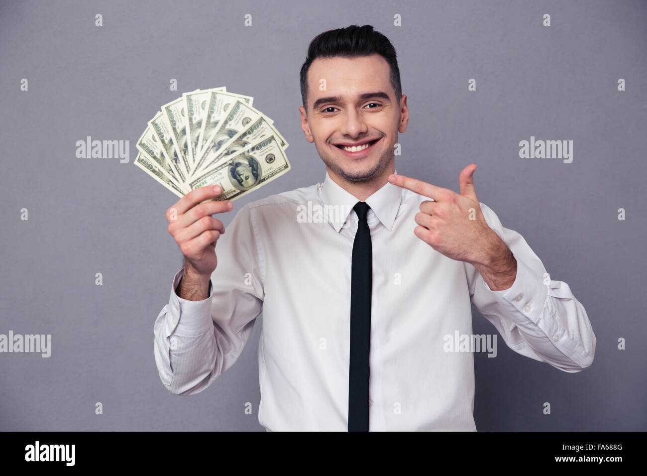 Portrait of a happy businessman holding money isolated on a white ...